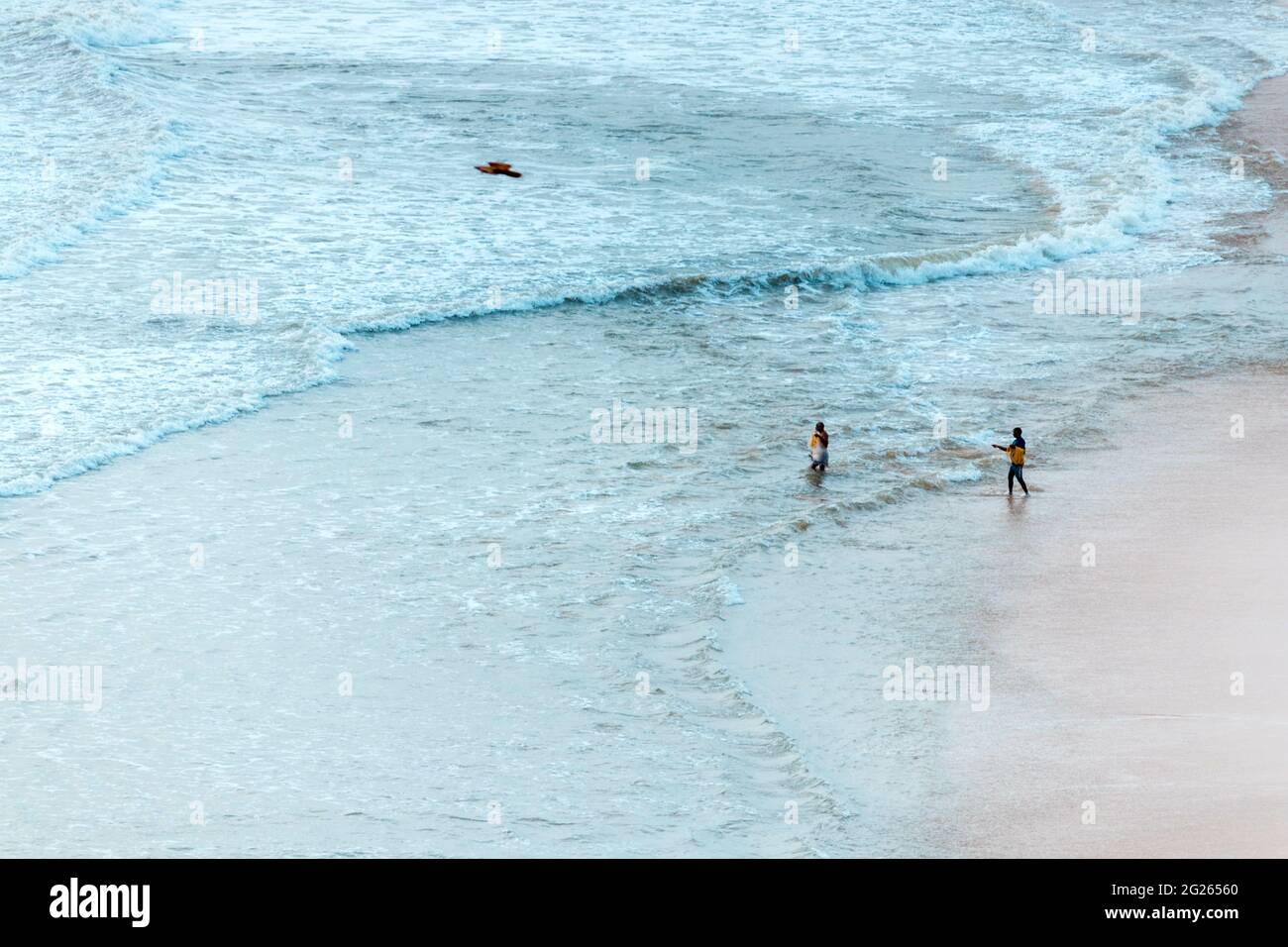 Aerial shot of two people on the wavy beach of ocean Stock Photo - Alamy