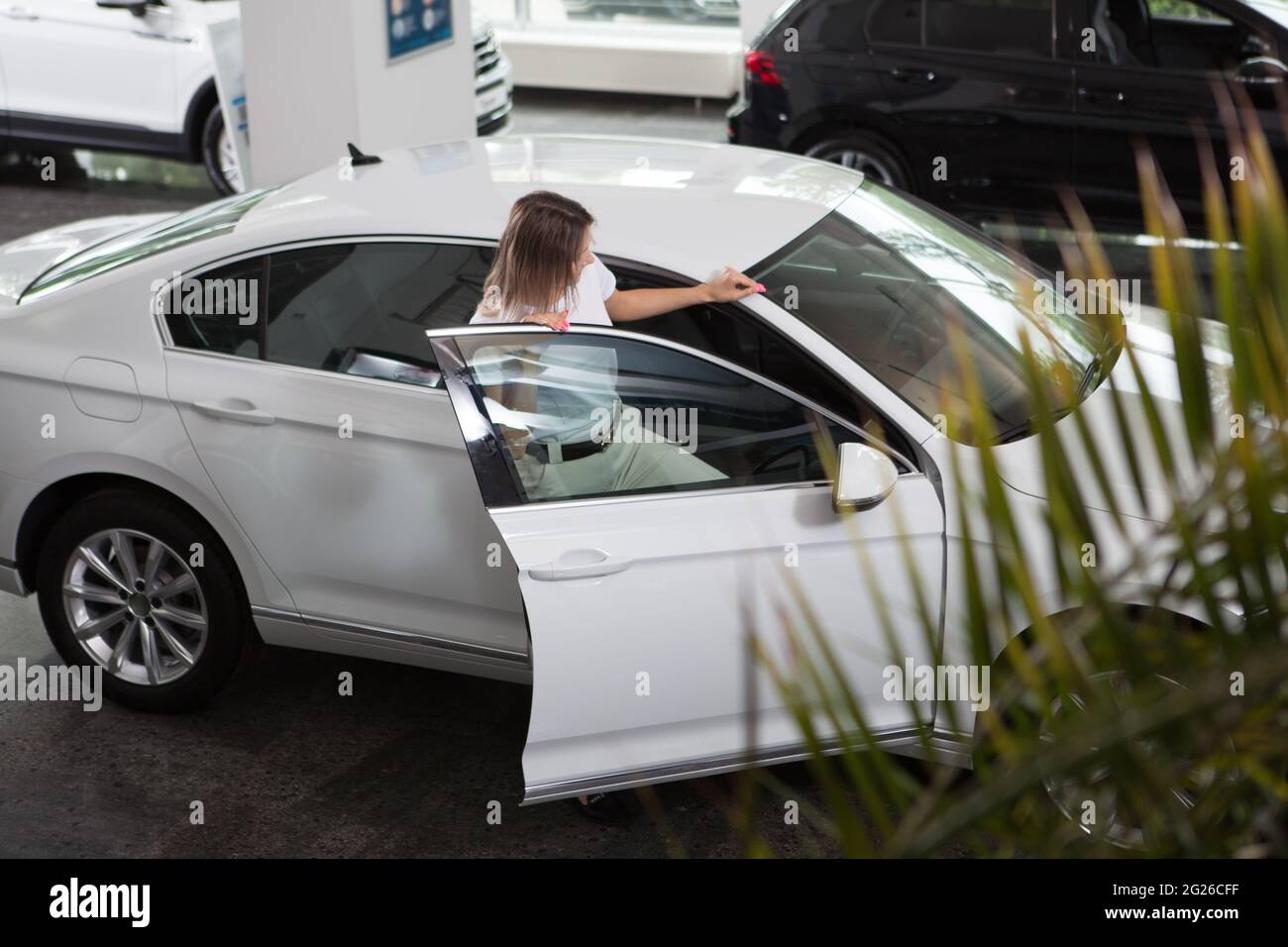 Top view shot of a female customer getting inside new car at car ...