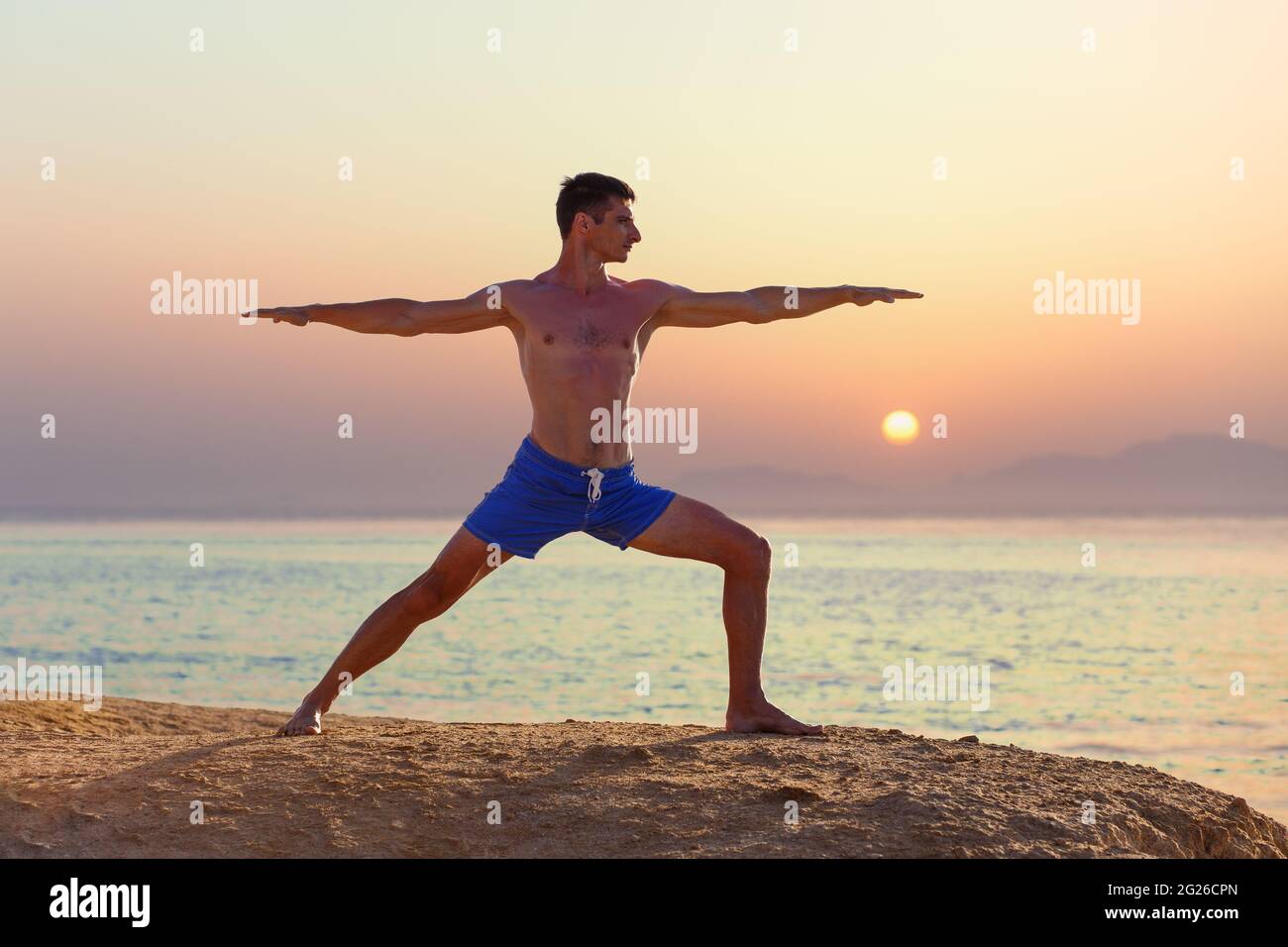 Young man beach practice yoga hi-res stock photography and images - Alamy