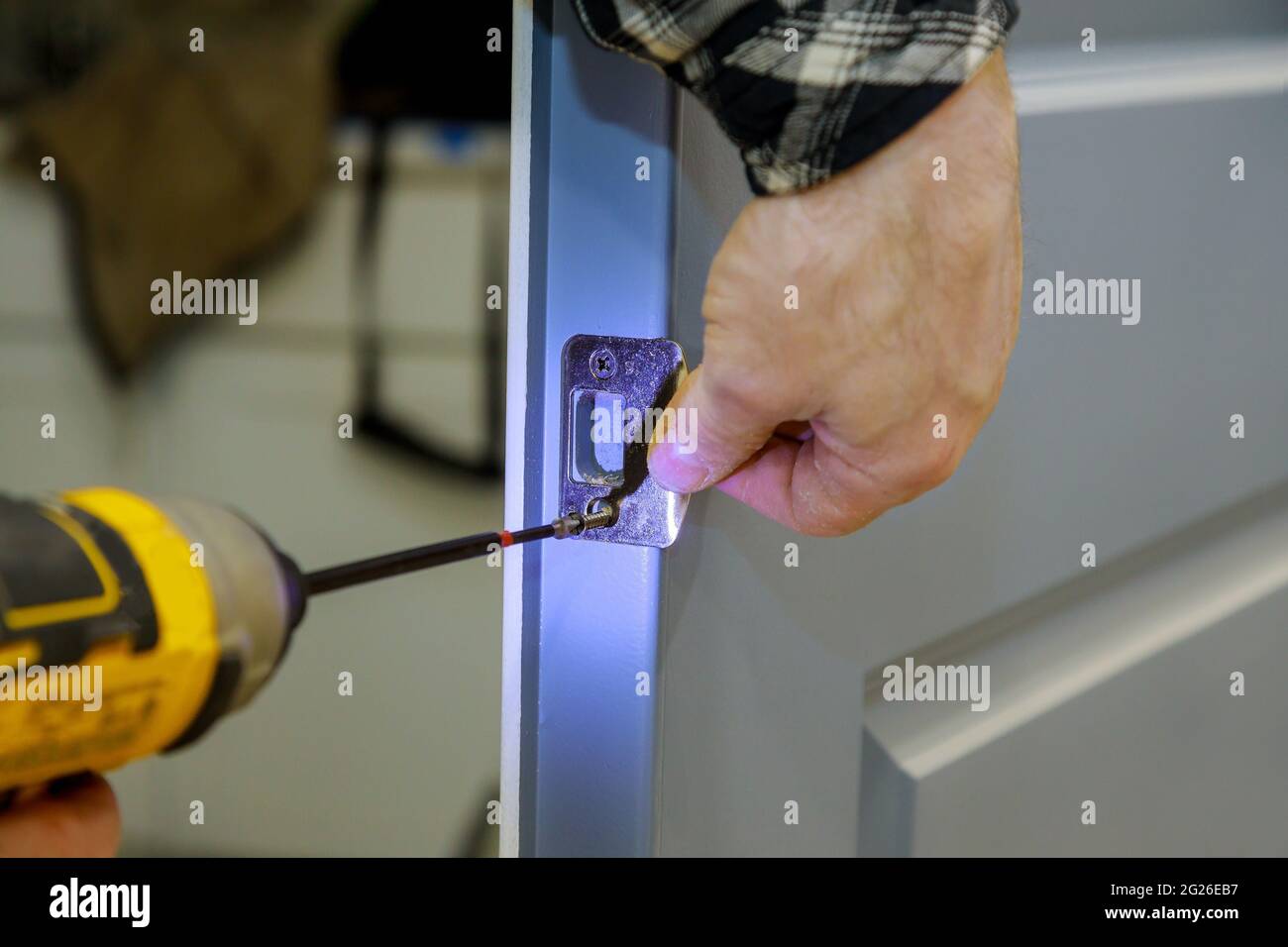 Carpenter installation at interior wood door lock Stock Photo - Alamy