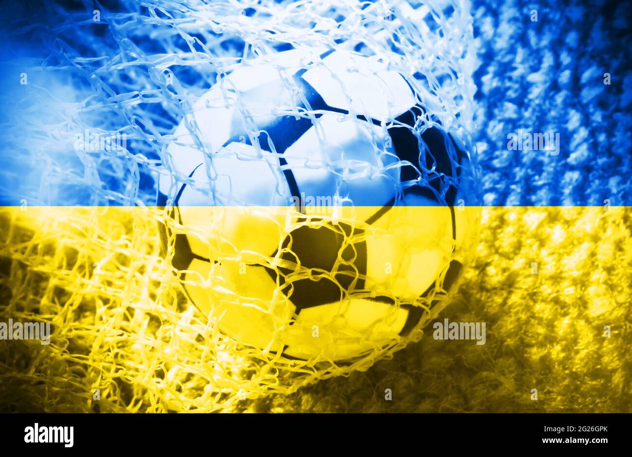 Soccer ball inside the net, with the Ukrainian flag as background ...