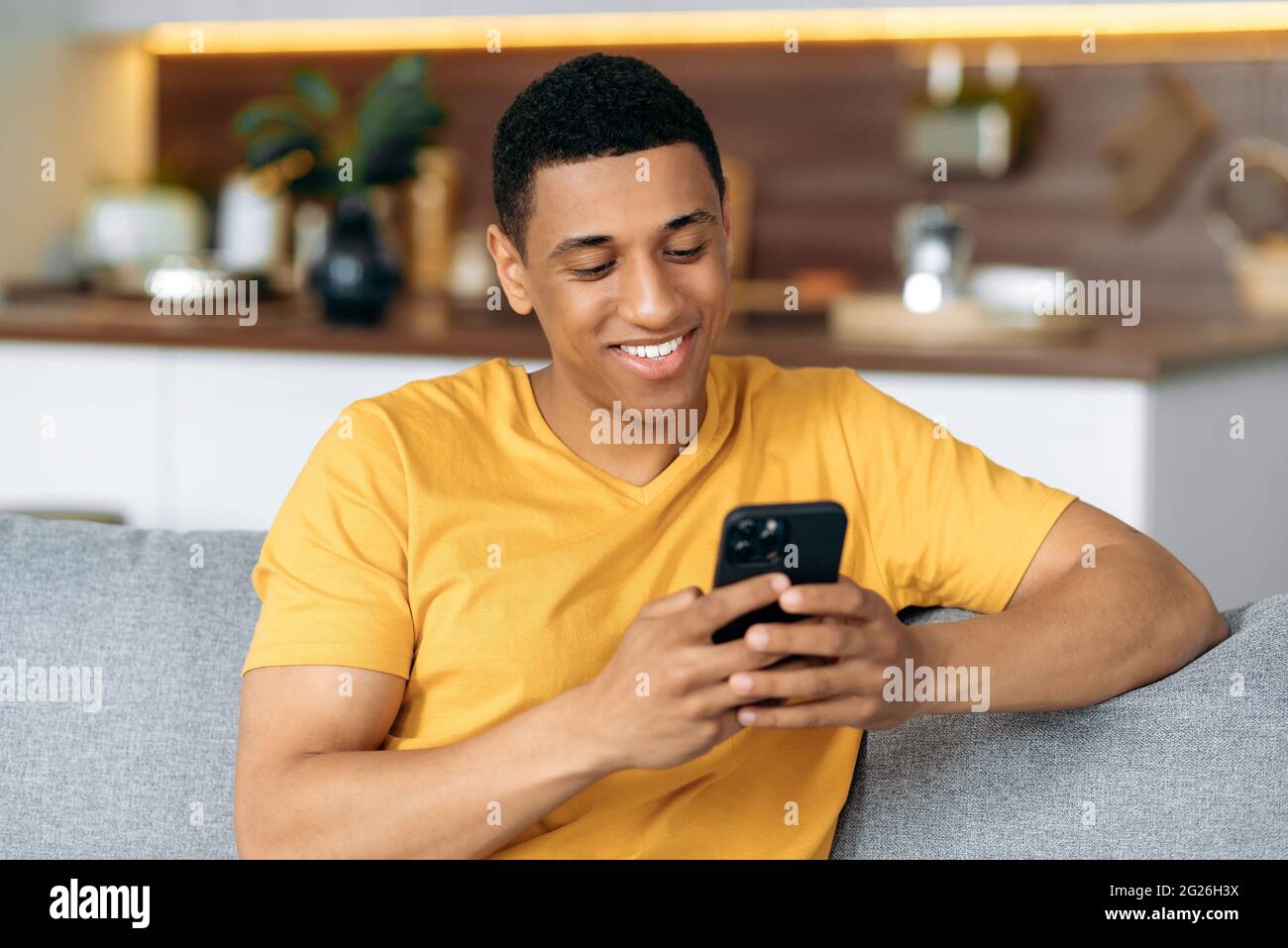 Hispanic man smartphone smiles hi-res stock photography and images - Alamy