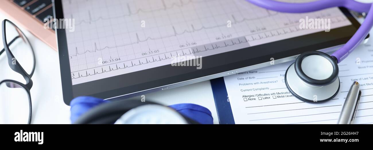 Digital tablet with electrocardiogram lying on doctors desk closeup ...