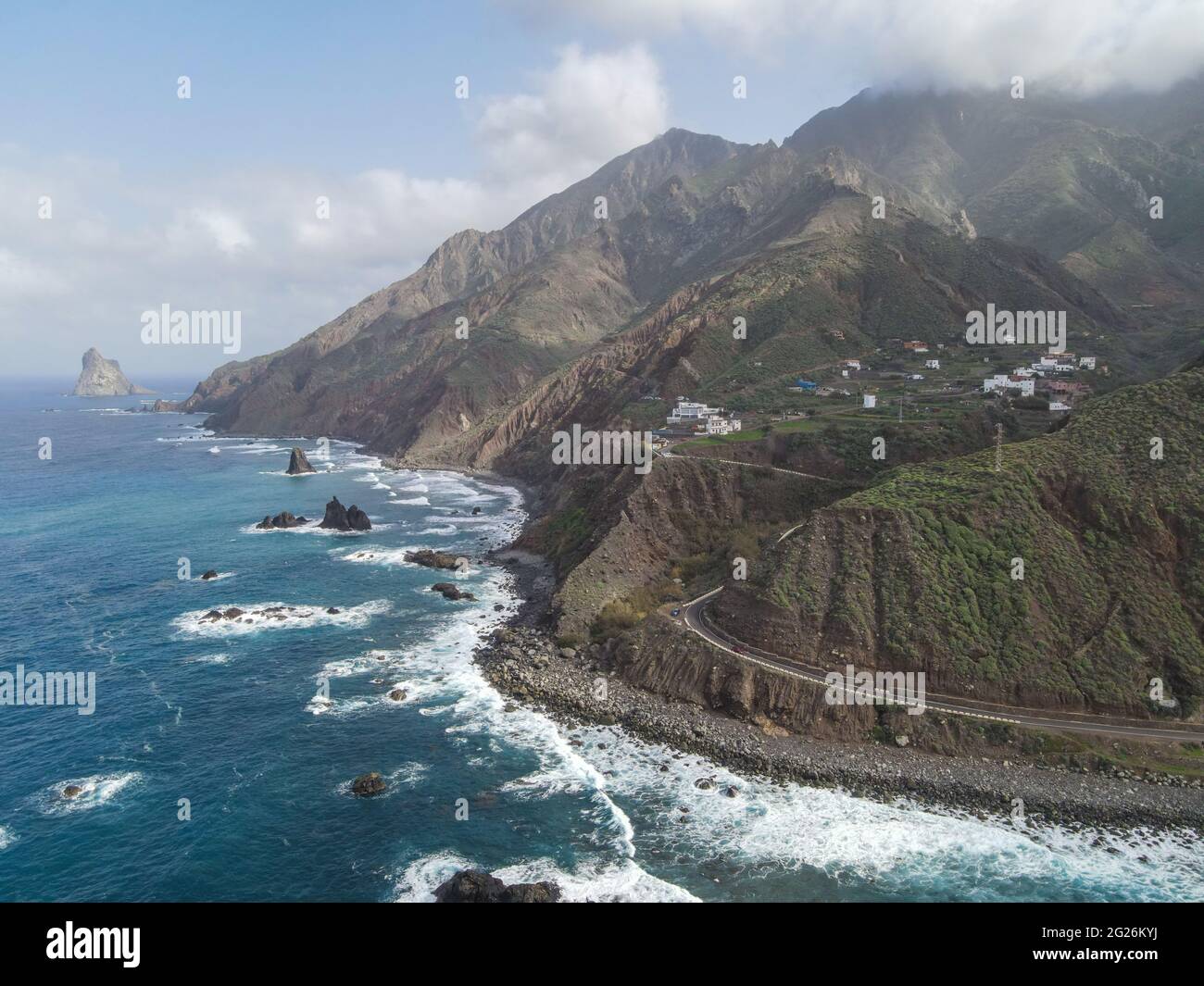 Mesmerizing view of an ocean surrounded by mountains under a cloudy sky ...