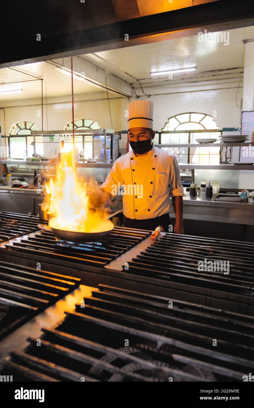 Mexican chef flaming in kitchen with sauce pan Stock Photo - Alamy