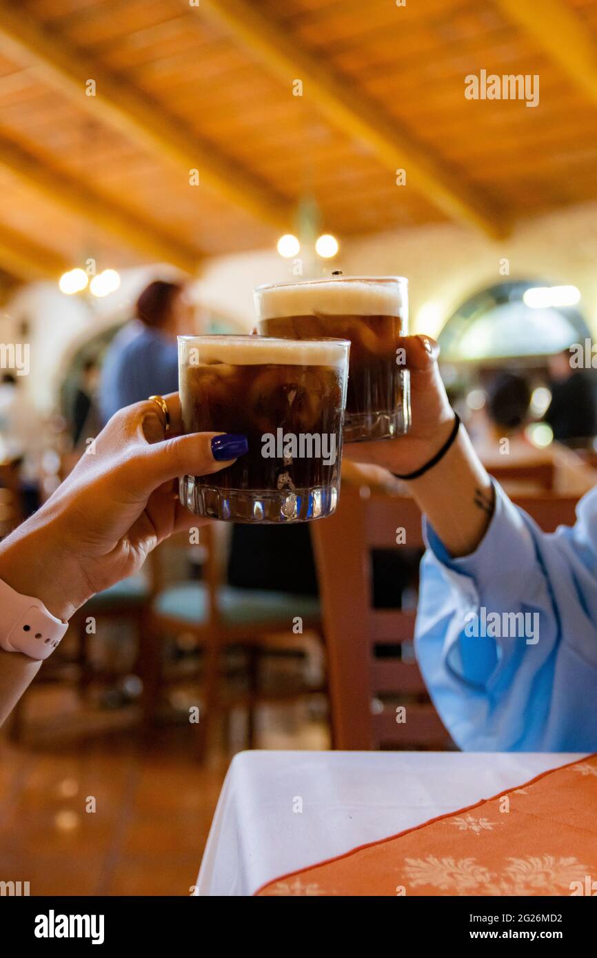Hands toasting with beverage in restaurant Stock Photo - Alamy