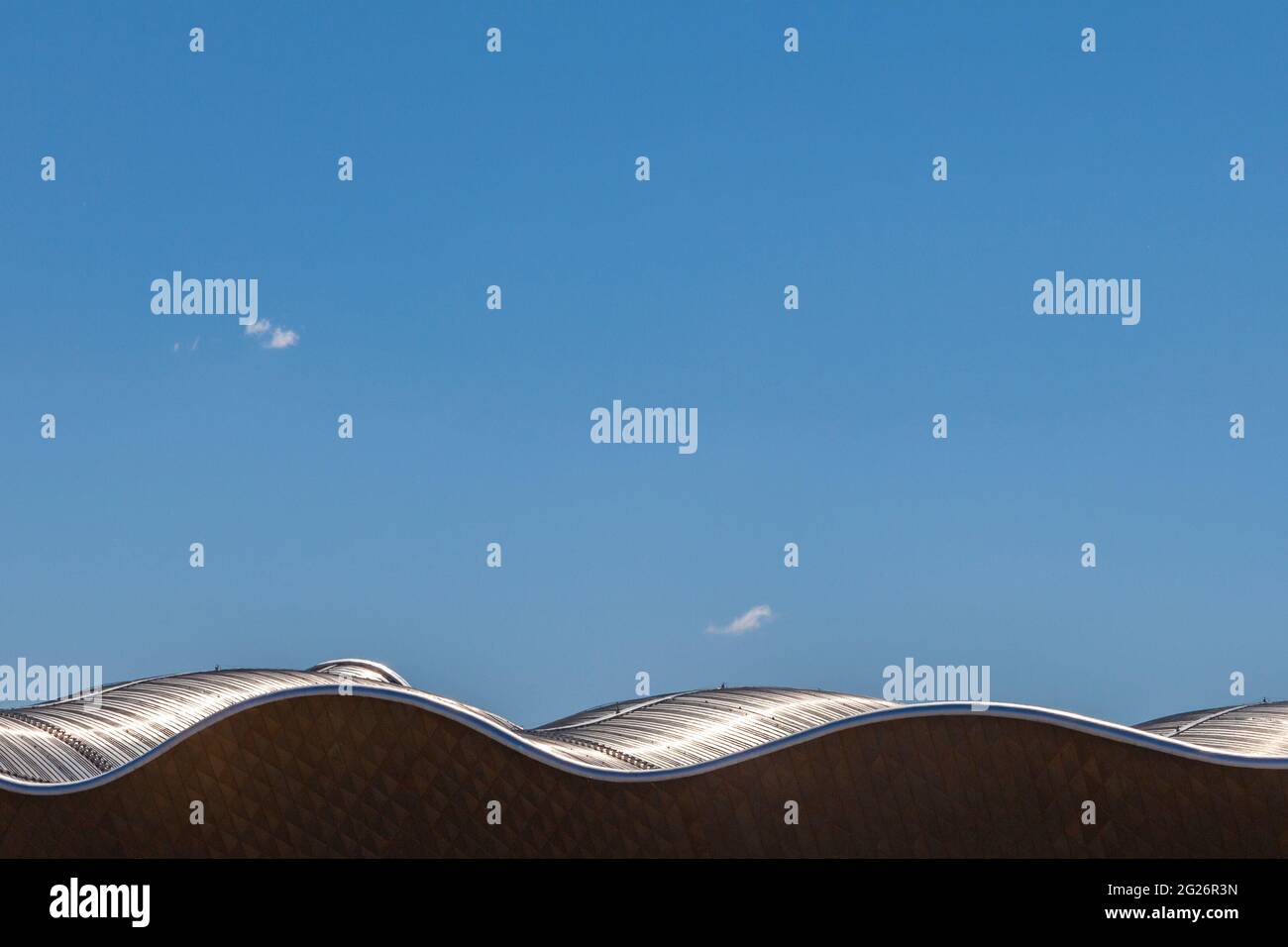 Wavy futuristic building roof against blue sky background Stock Photo ...