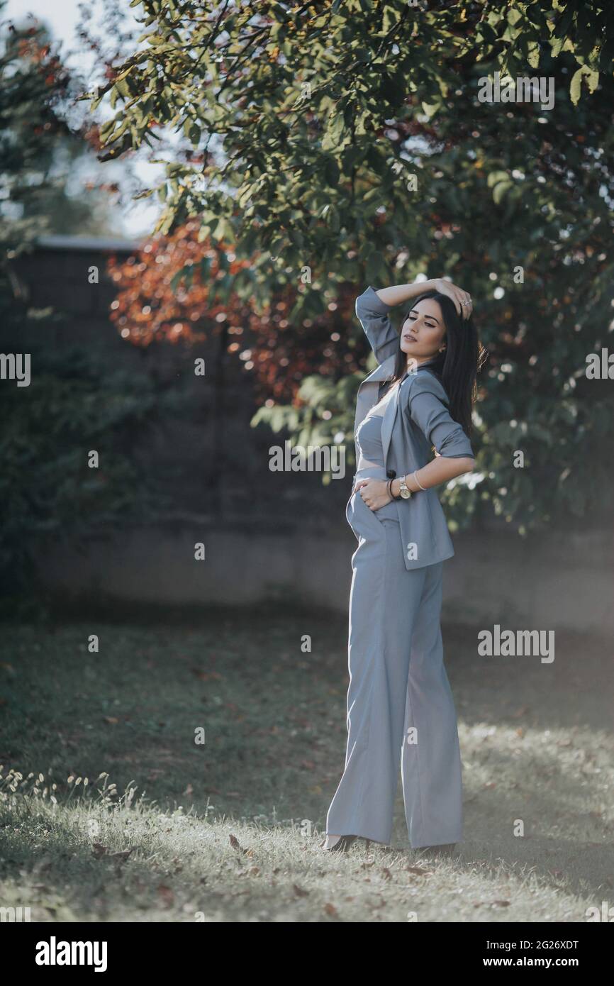 Shallow focus of an adult woman wearing a gray suit with a crop top in ...
