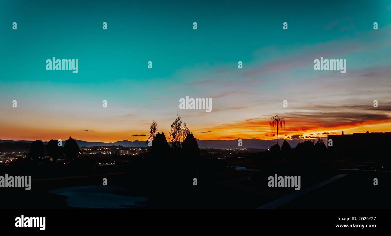 Summer sunset landscape with a skyline of a city and blue and yellow ...