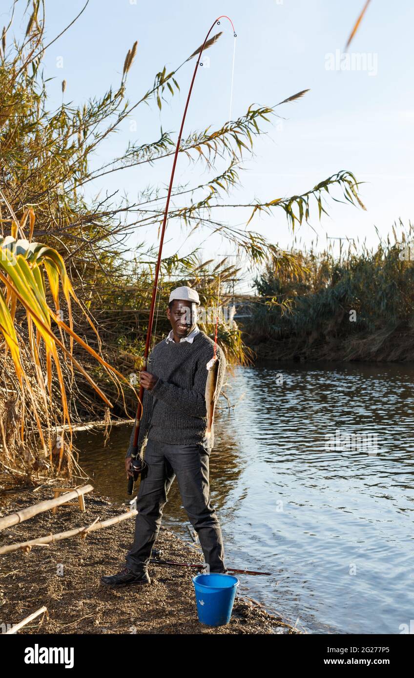 Man pulling fish on hook Stock Photo - Alamy