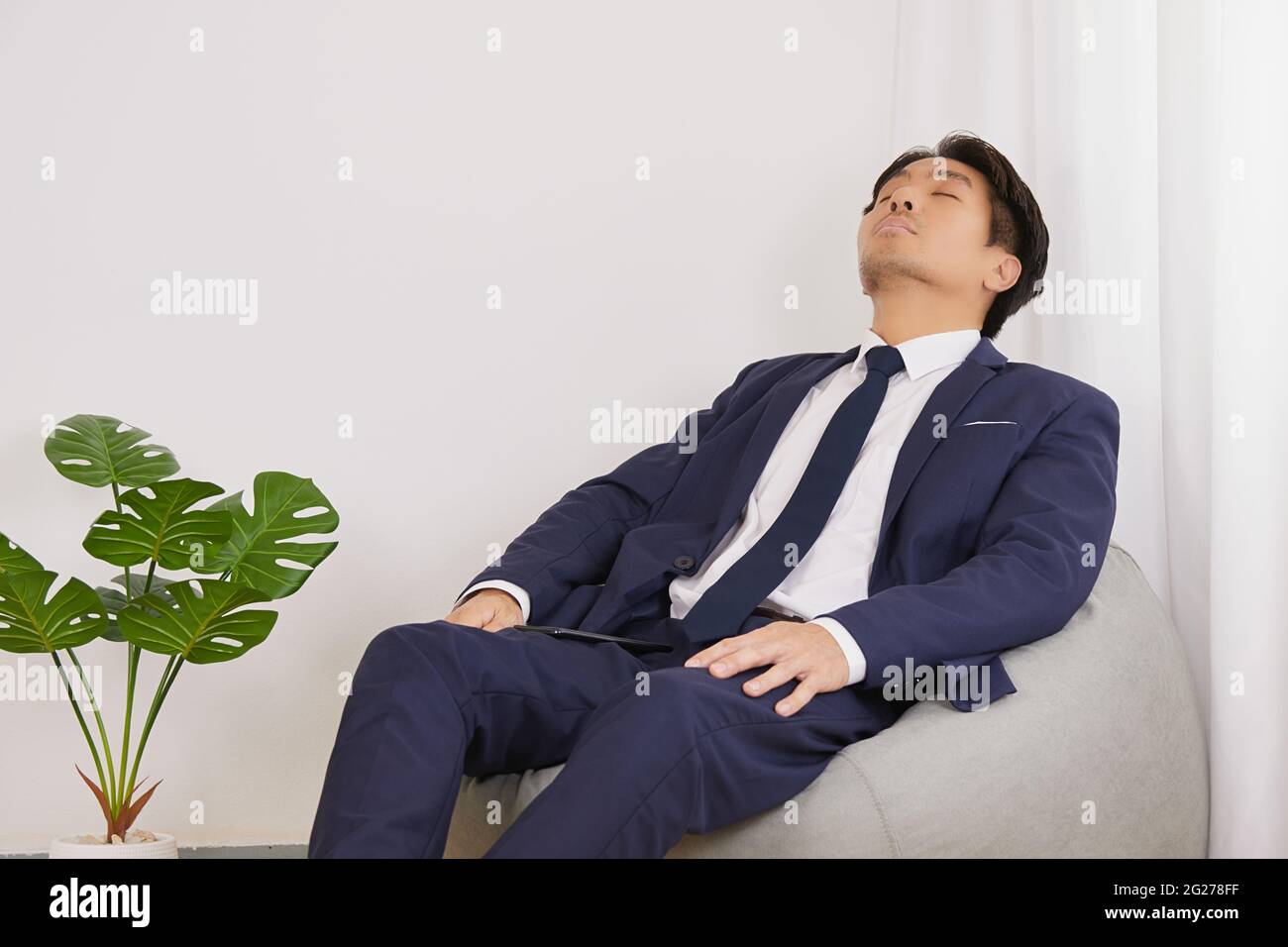 Asian Businessman in Suit Rest His Eyes or Nap or Sleep on Bean Bag in ...