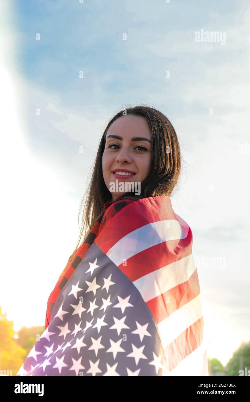 Young millennial brunette woman holding The National Flag of USA ...