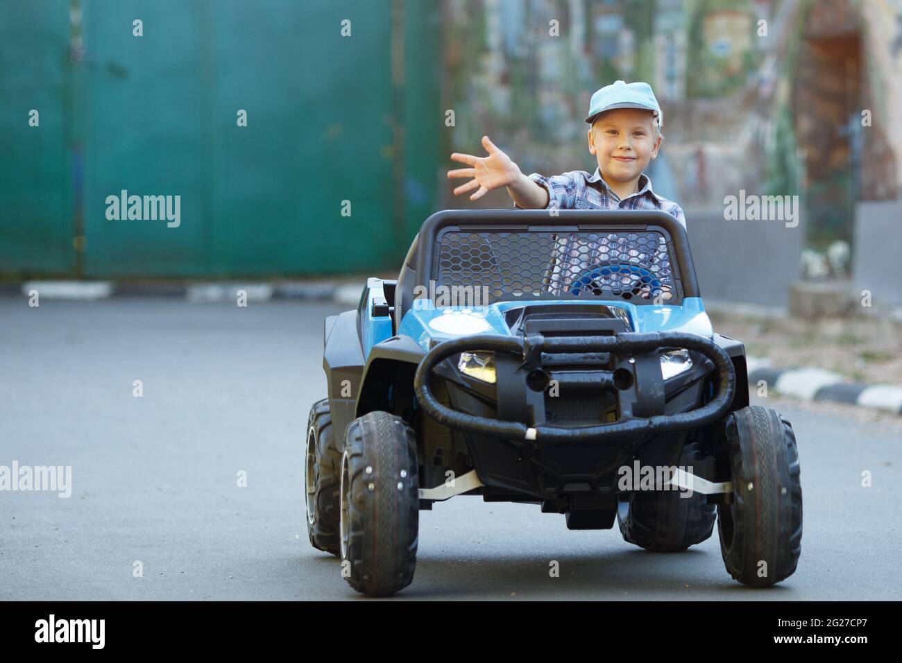 The boy plays, drives a car in the park. A cute little boy of Caucasian ...