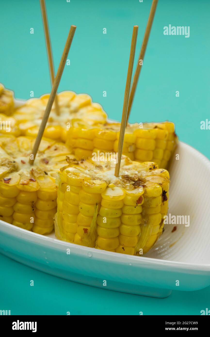 Corn, a snack made using ripe corn and garnished with chilli flakes and ...