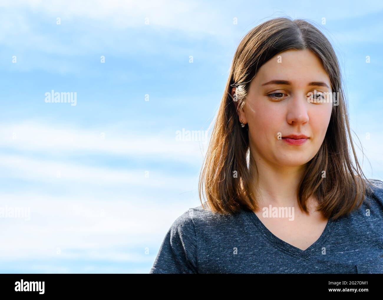 Portrait of a young woman against a blue sky with clouds Stock Photo ...