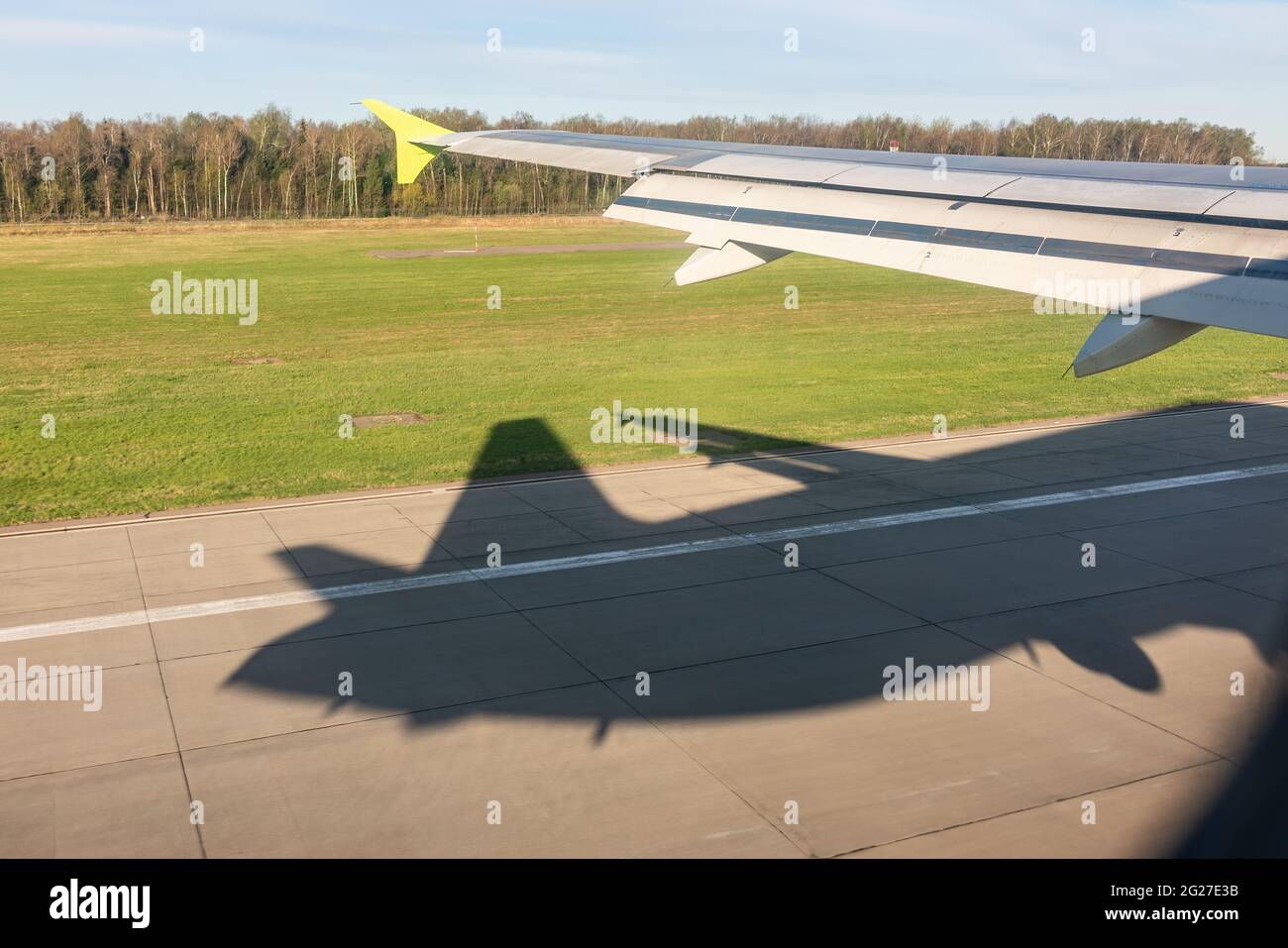 View of airplane wing, Shadow of the plane on the ground during landing ...