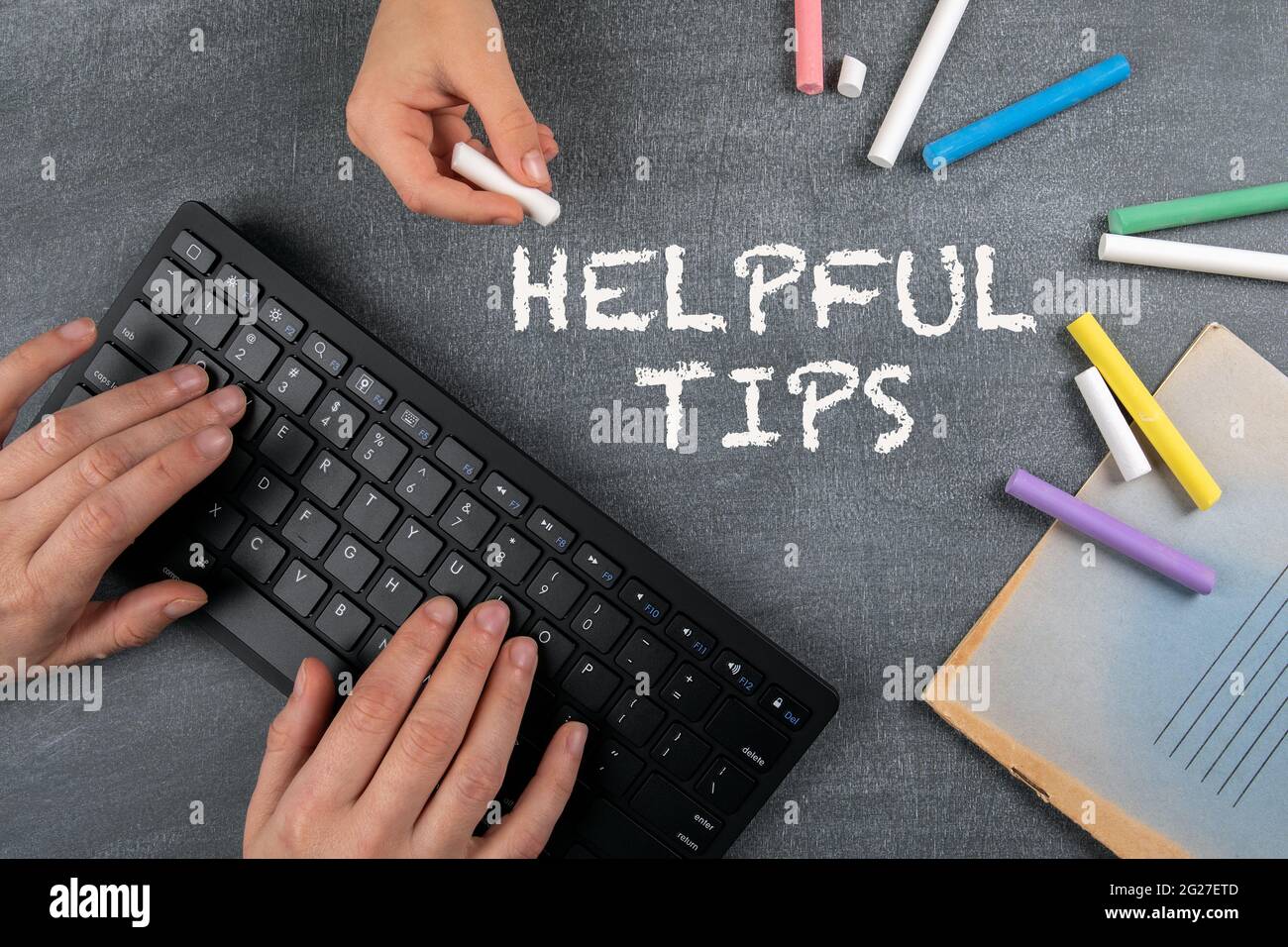 Helpful Tips. Computer keyboard with colored pieces of chalk on a ...