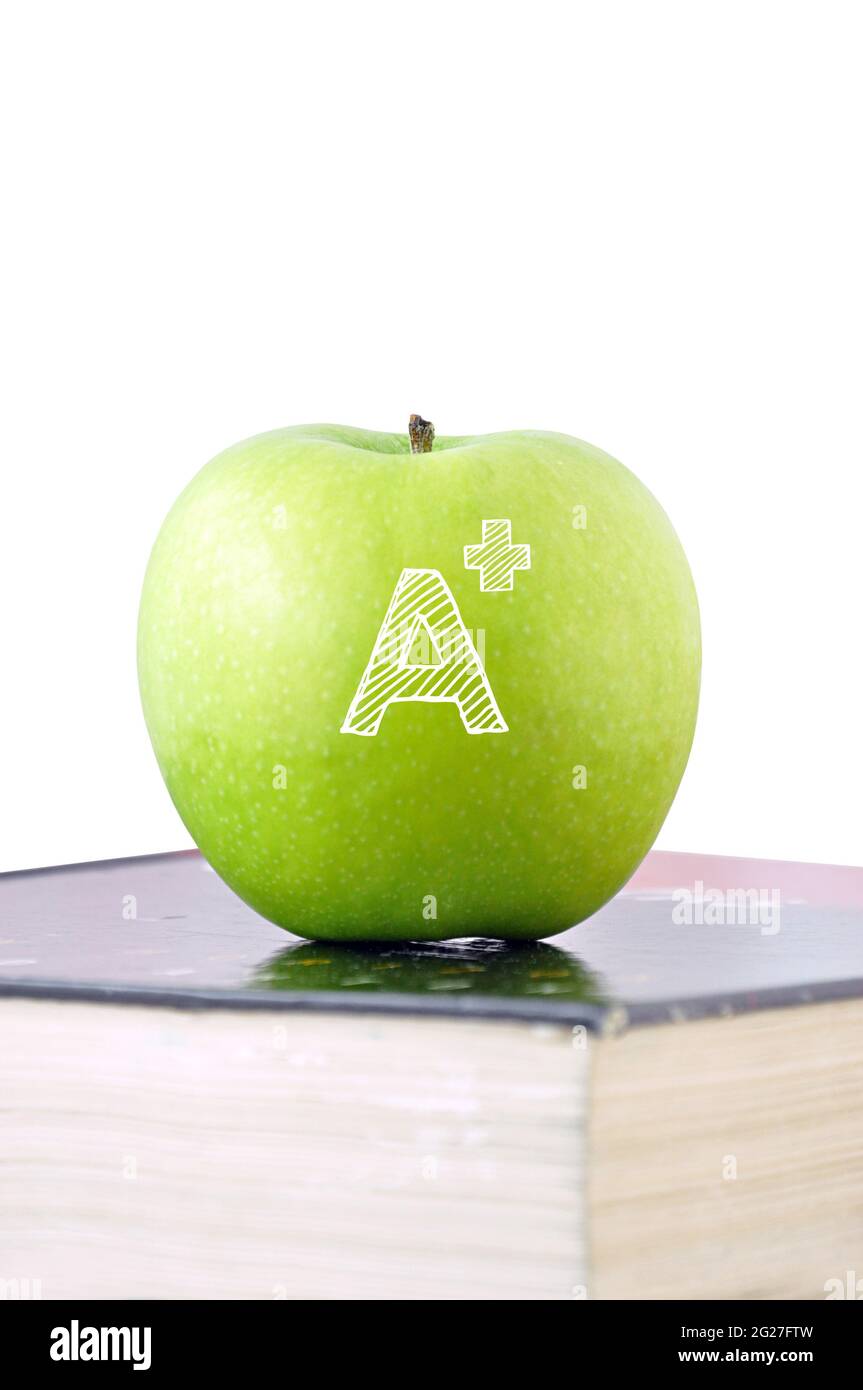 Green apple with A+ sign on a textbook Stock Photo - Alamy