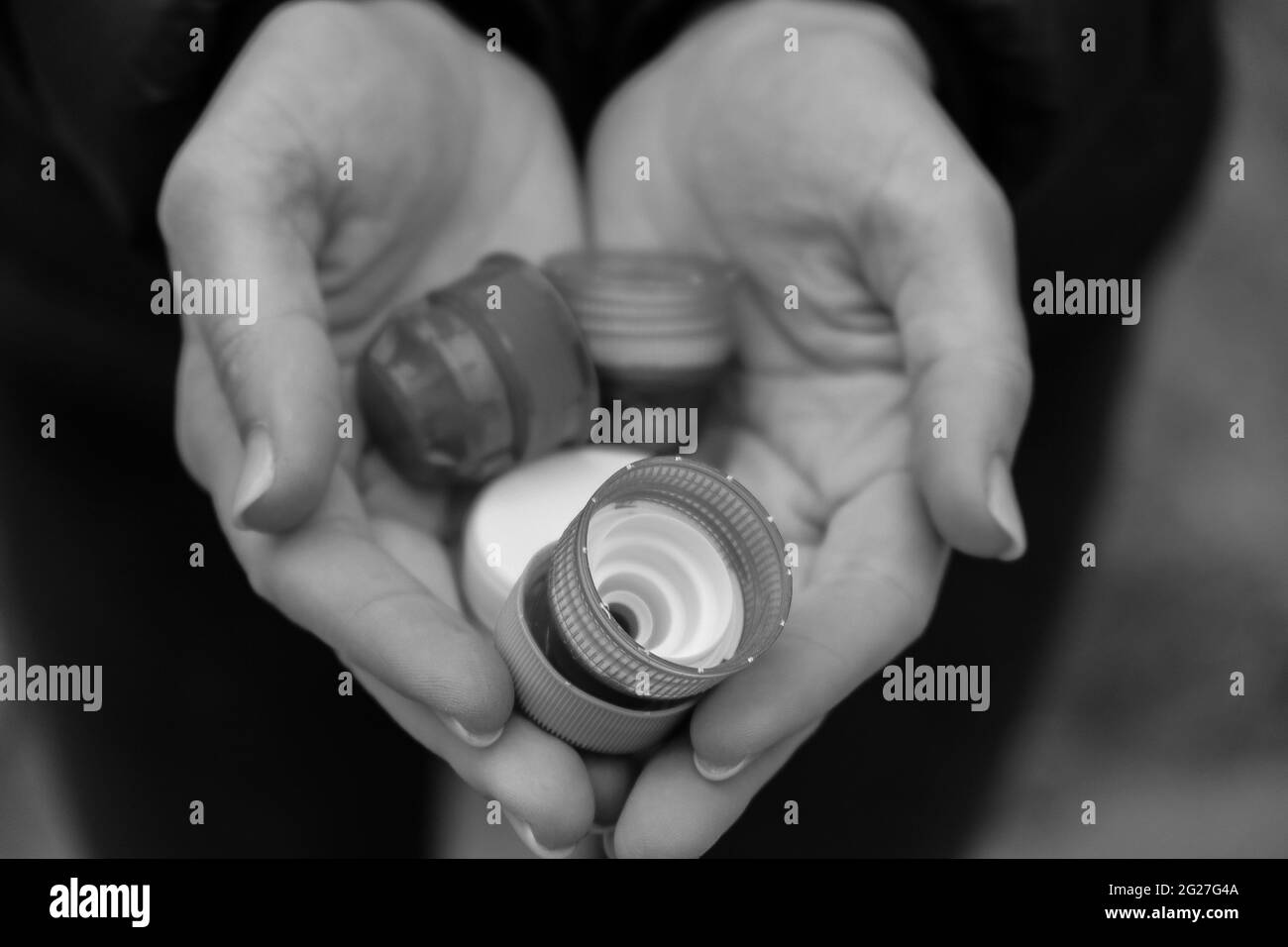 Black and white Closeup at caucasian female hands full of plastic ...