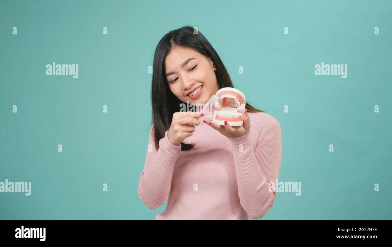 Asian young beautiful woman smile showing model how to clean the teeth ...