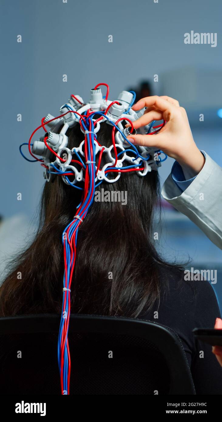Woman patient wearing performant eeg headset scanning brain electrical ...