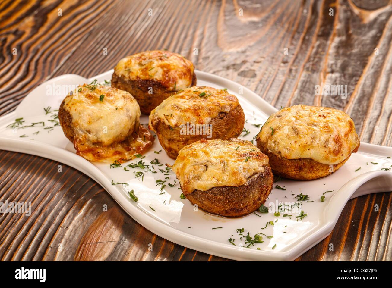 Baked champignon with cheese and green herbs Stock Photo - Alamy