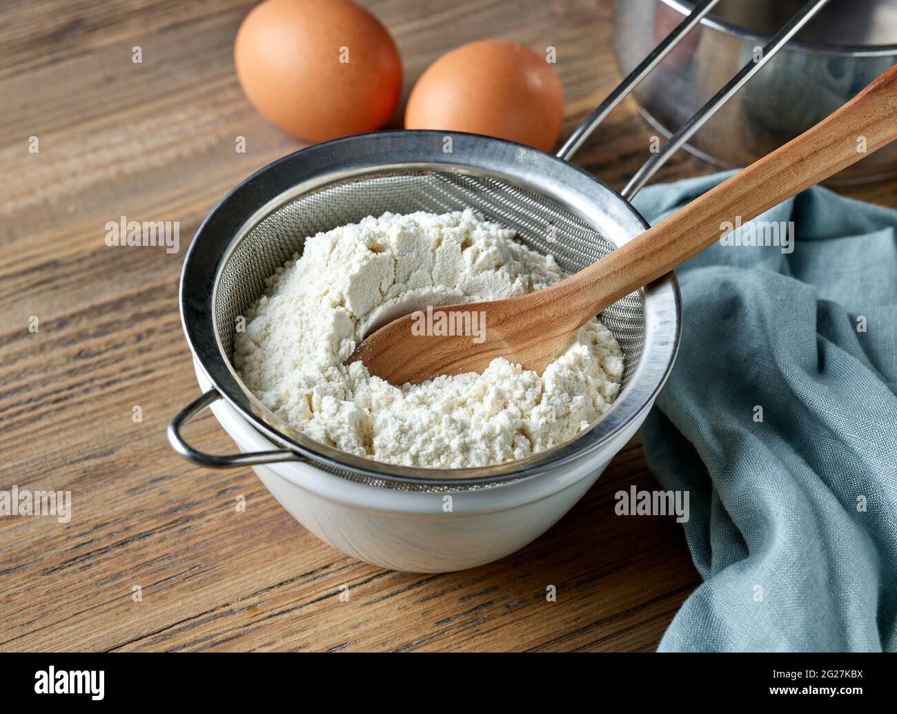 bowl and flour in strainer on kitchen table for making dough Stock ...