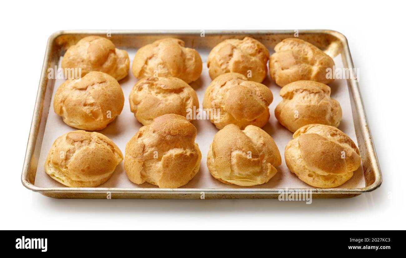 freshly baked cream puffs on baking pan isolated on white background ...