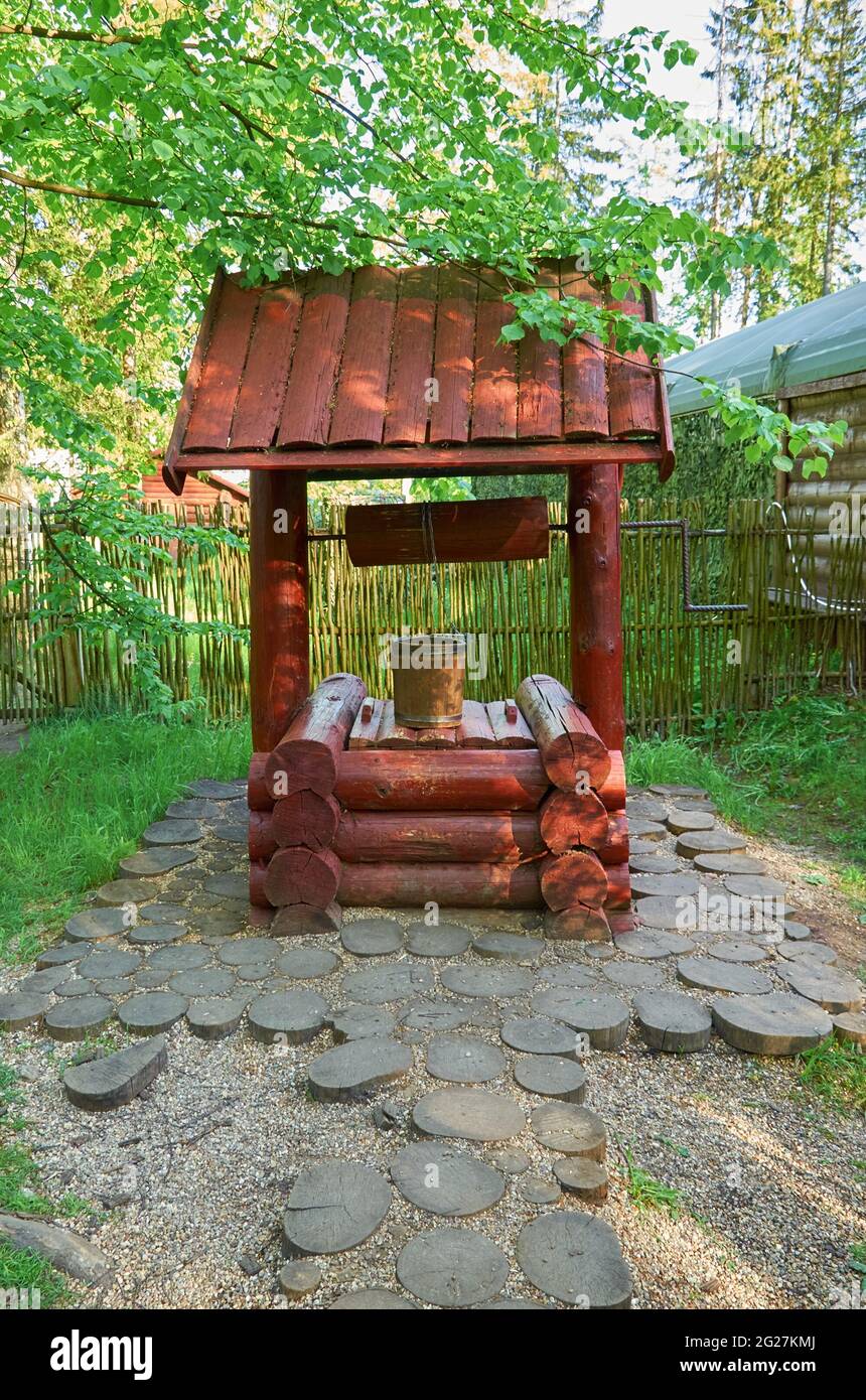 Wooden well with a bucket in the village yard Stock Photo - Alamy