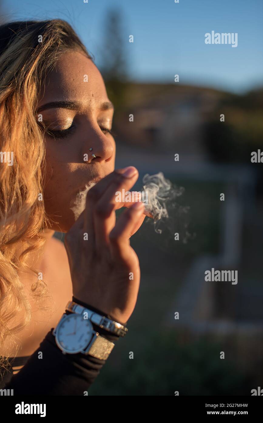 Portrait of young woman smoking a marijuana joint Stock Photo - Alamy