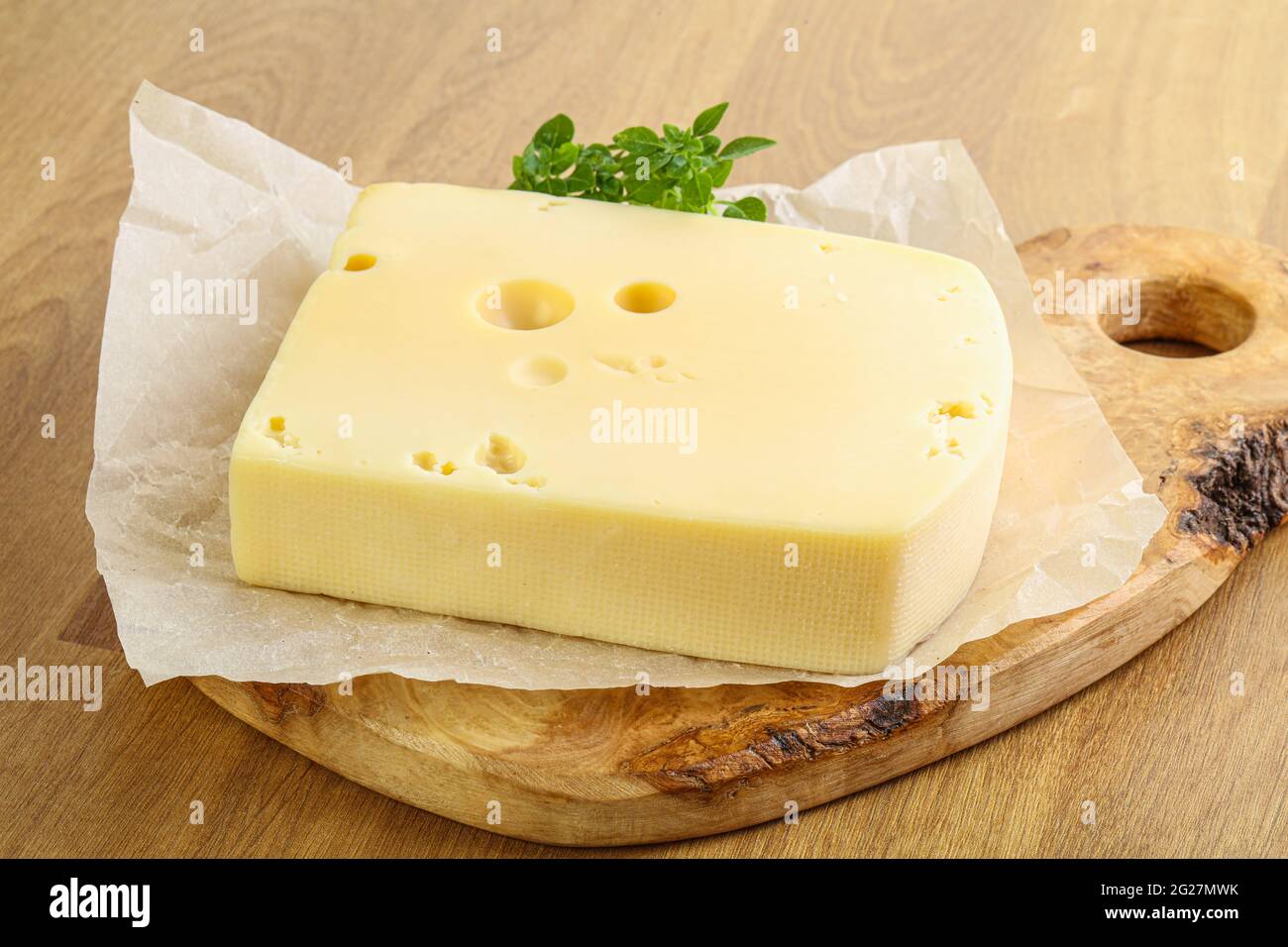 Maasdam cheese brick over the board Stock Photo - Alamy