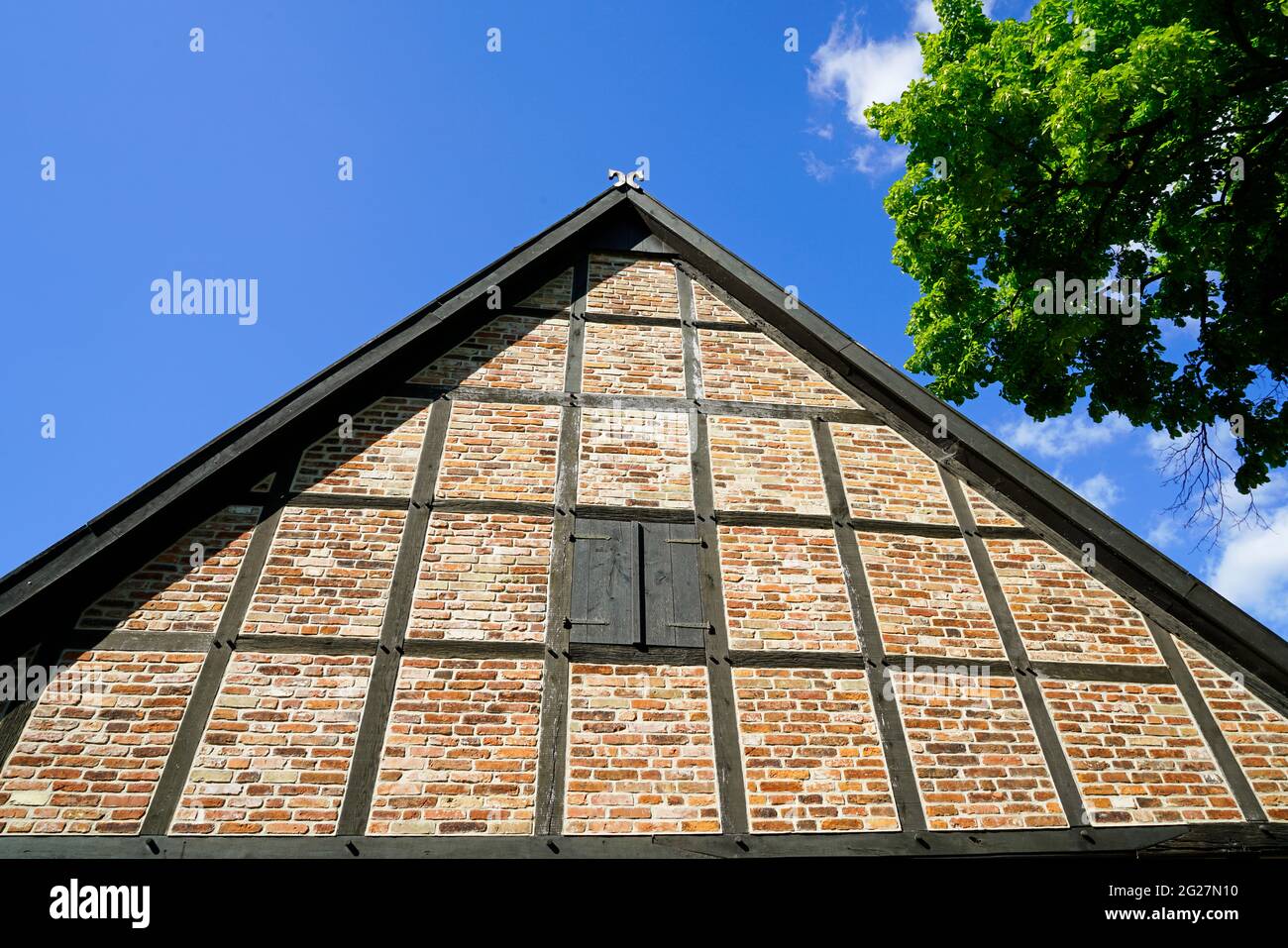 Facade of an old half-timbered house. Wooden structure filled with red ...