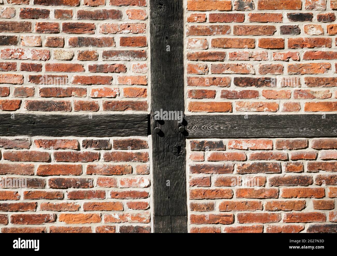 Facade of an old half-timbered house. Wooden structure filled with red ...