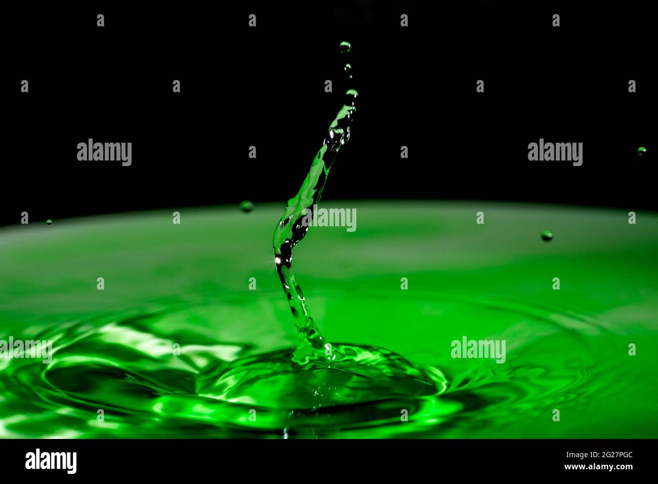 Clear water drop on a green tinted water Stock Photo - Alamy