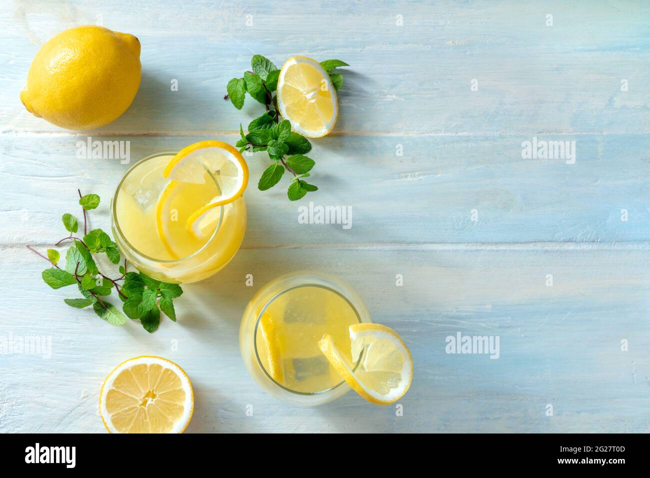 Lemonade flat lay with copy space. Homemade fresh drink with lemon and mint, overhead on a ...