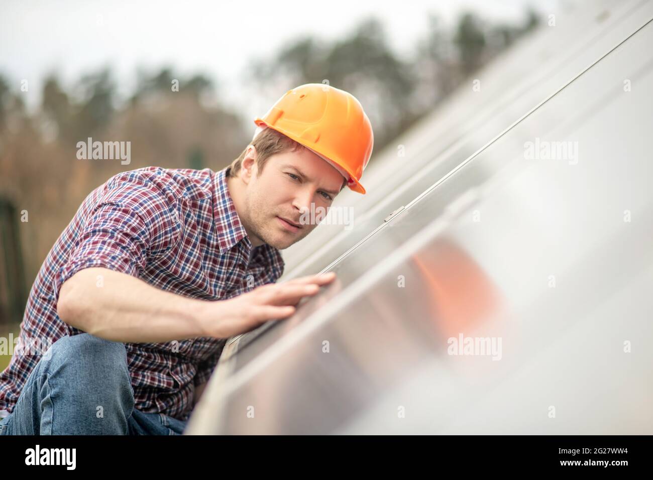 Man in helmet checking surface of object Stock Photo - Alamy