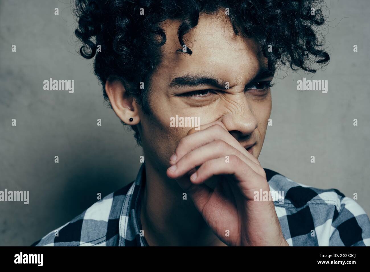 emotional guy in a plaid shirt on a gray background laughing confusion ...