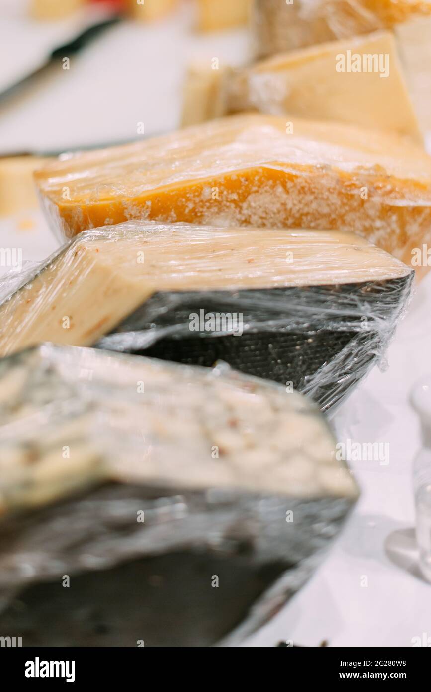 Handmade cheese wrapped in polyethylene lies on the counter Stock Photo ...