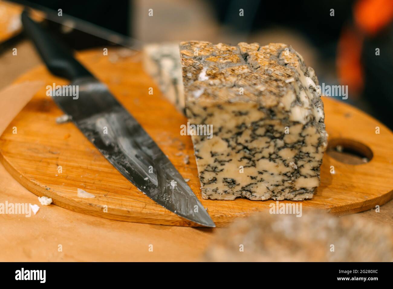 Handmade blue cheese chunks on the sample counter next to the knife ...