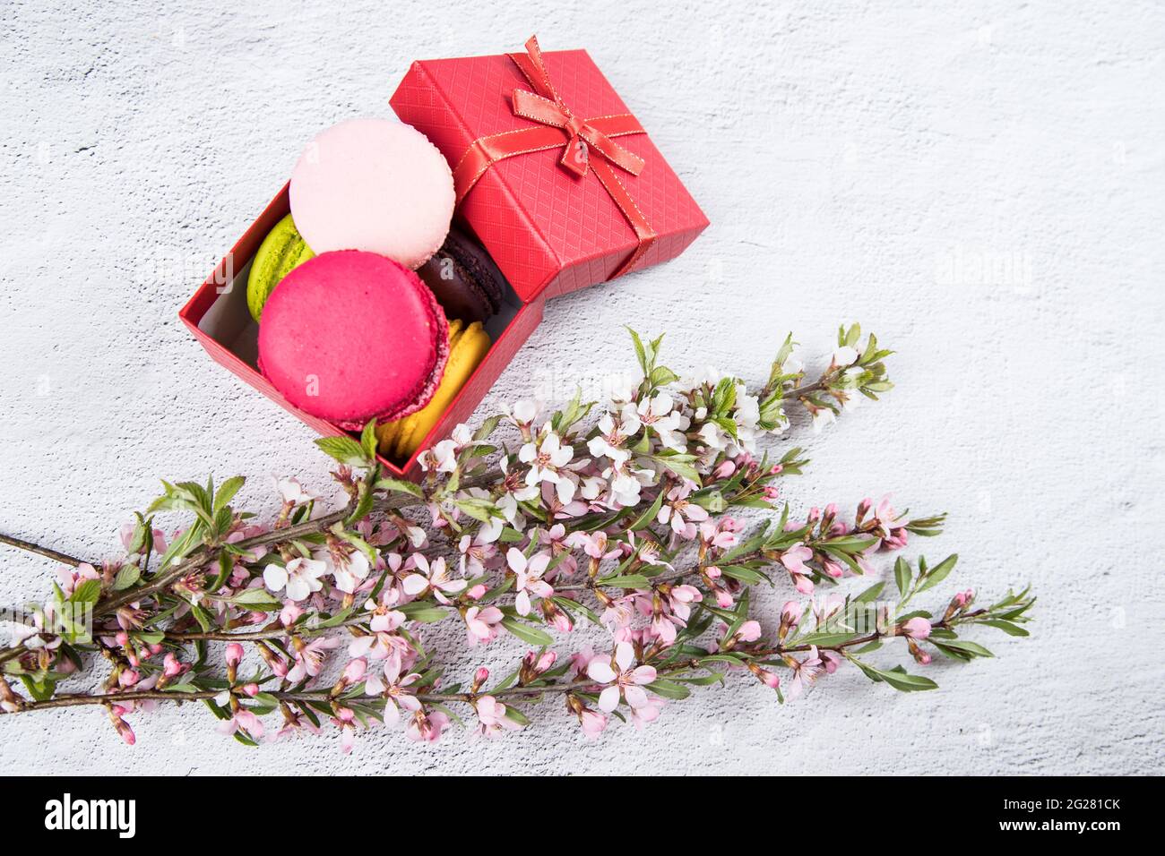 Macaroons cookies in a beautiful gift box with flowering branches on a ...