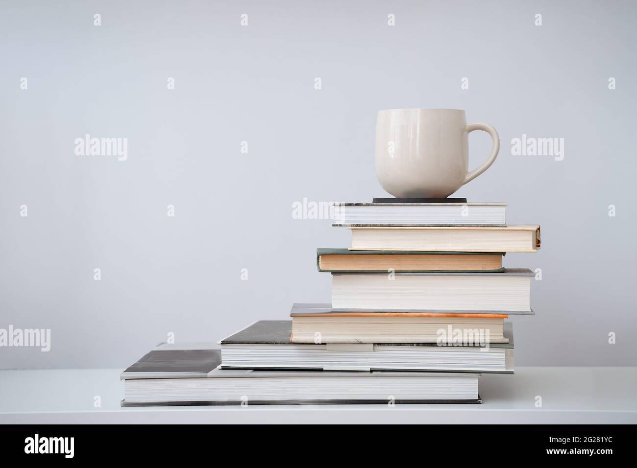coffee cup tea mug on stack of books on white background. Front view ...