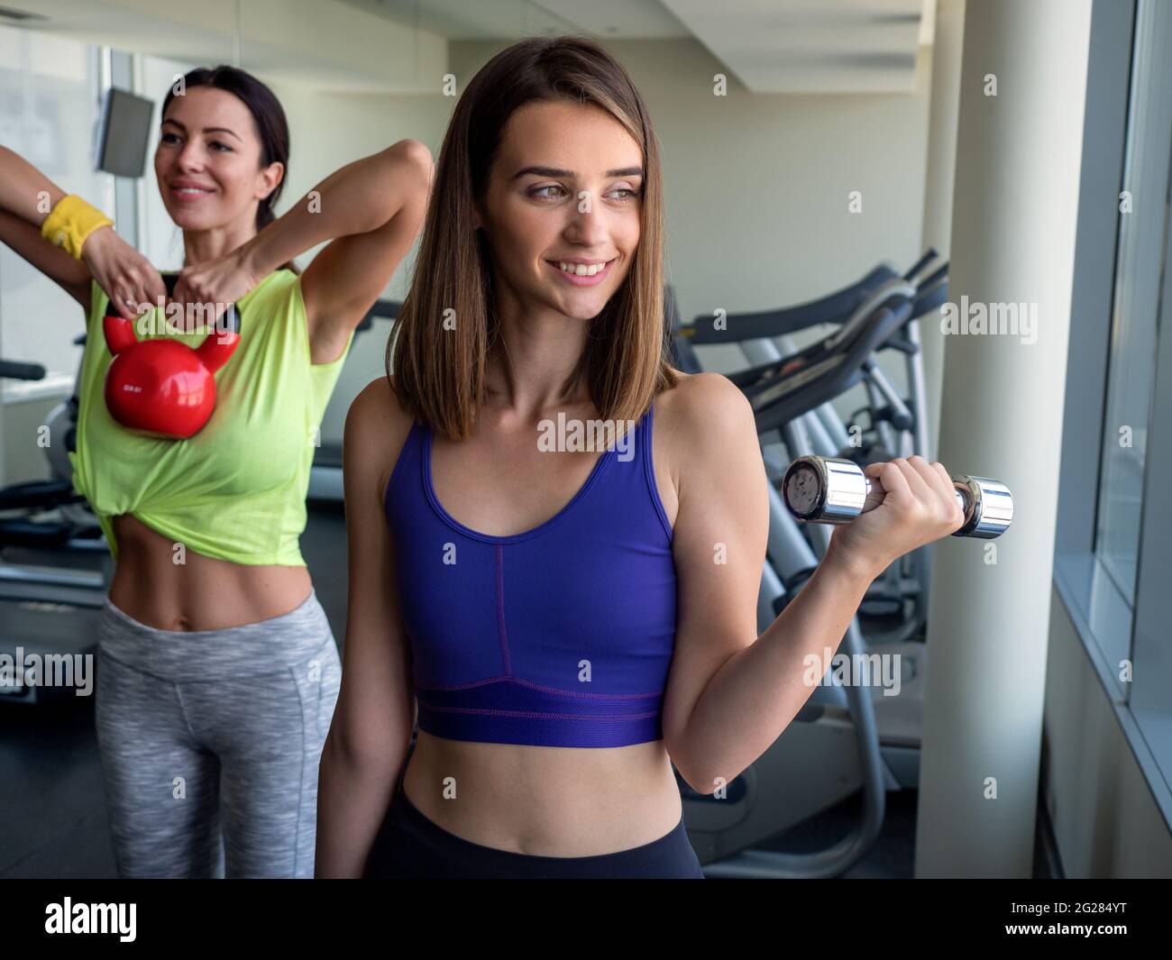 Happy beautiful women working out in gym together Stock Photo - Alamy