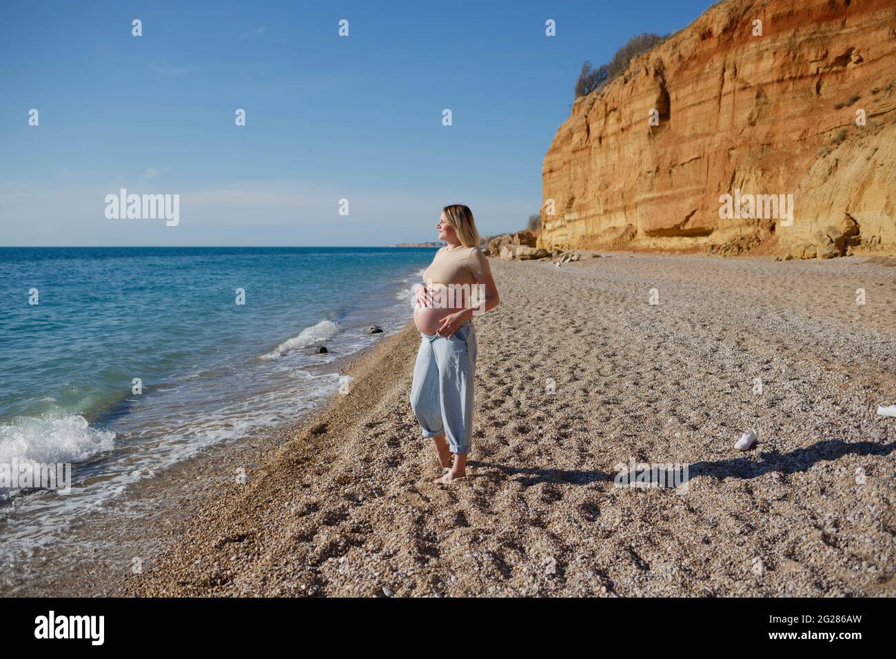 Pregnant woman sunbathing on beach hi-res stock photography and images ...