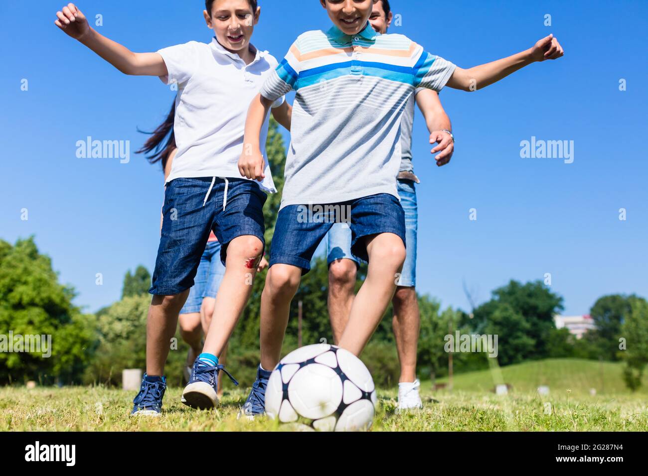 Family playing football in park hi-res stock photography and images - Alamy