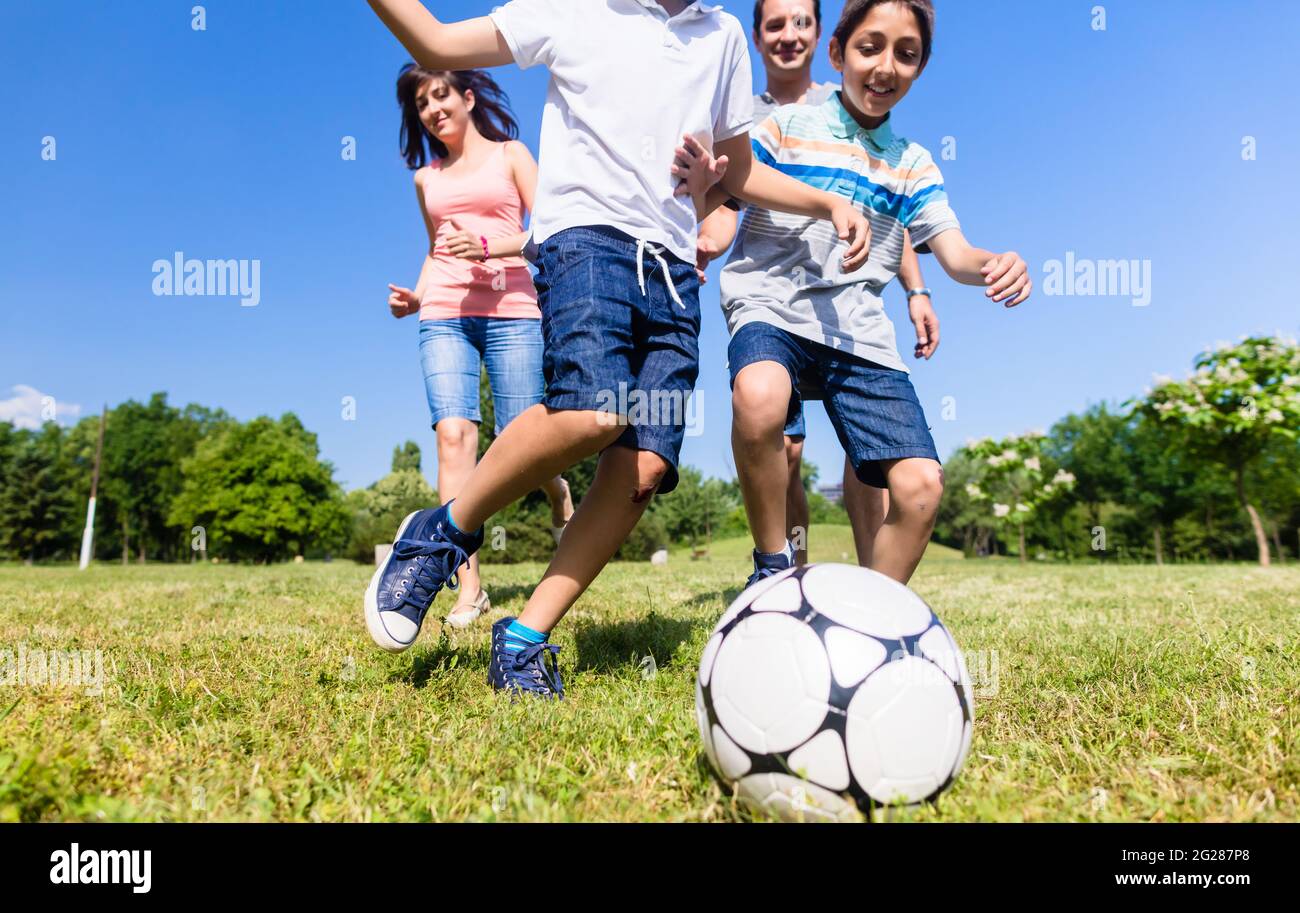 Family playing football or soccer in park in summer Stock Photo - Alamy