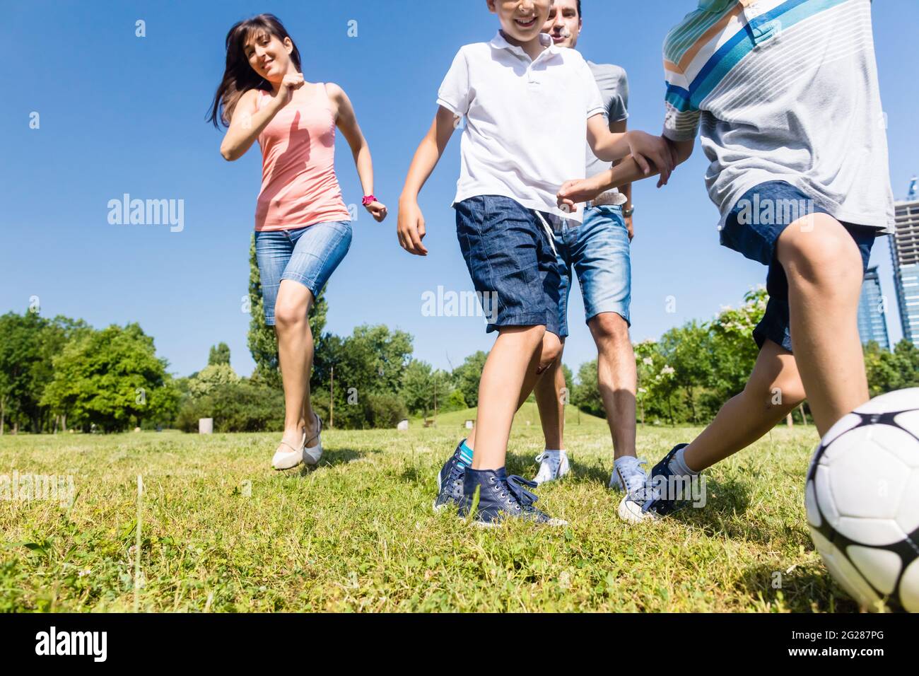 Family playing football or soccer in park in summer Stock Photo - Alamy