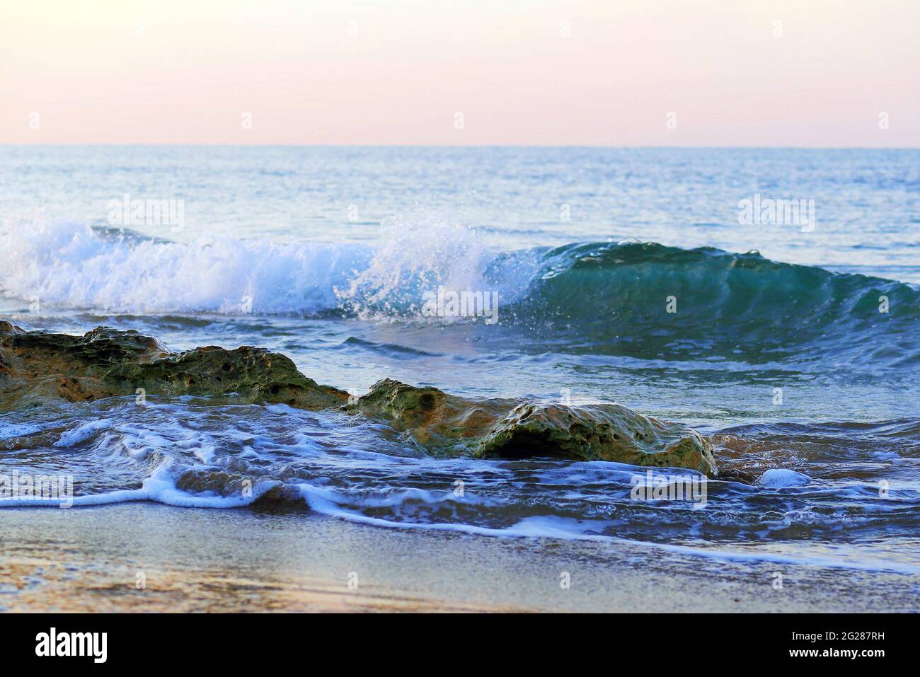 rocks at beach and rolling wave at background Stock Photo - Alamy