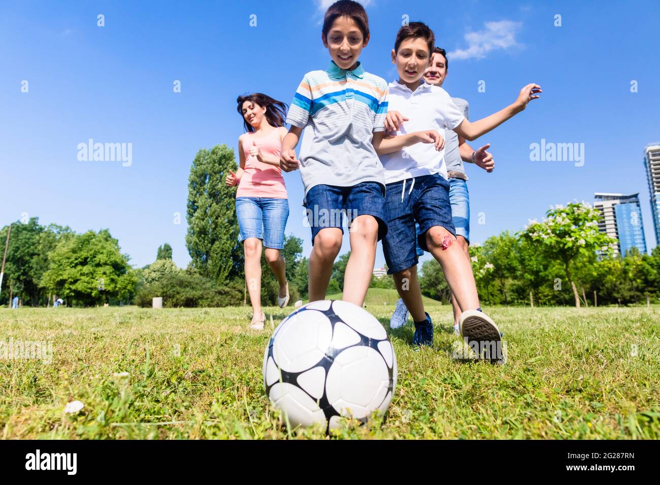 Family playing football or soccer in park in summer Stock Photo - Alamy