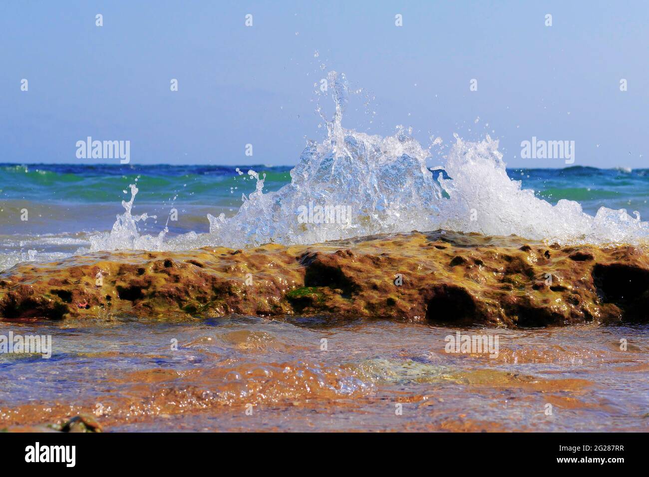 wave splashing on stones on beach Stock Photo - Alamy