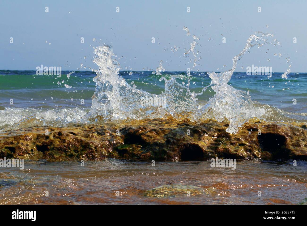 wave splashing on stones on beach Stock Photo - Alamy